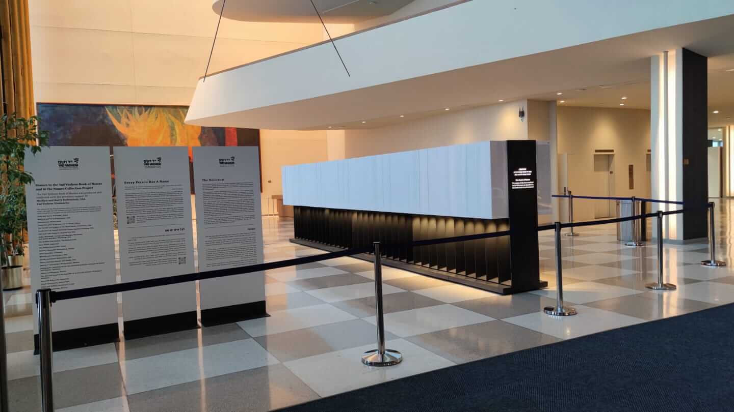 An exhibit invites visitors to touch the names of Holocaust victims ...